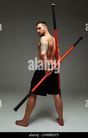 athlete men with stick training karate using sports tool in studio on ...