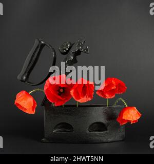 Papaver rhoeas flowers with 1920s charcoal iron box. Red poppies bloom ...