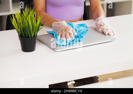 Woman wipes the laptop with a damp disinfectant wipe Stock Photo - Alamy