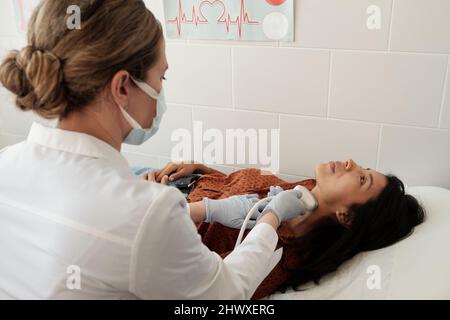 Young woman getting thyroid ultrasound examination in modern clinic ...
