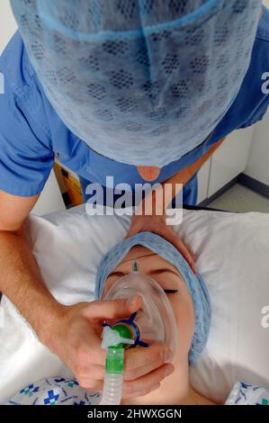 Anaesthesia. Anaesthetist administering gas to a patient. The gas is a ...