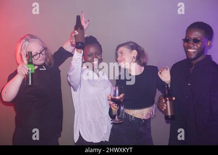Hazy shot of diverse people dancing at party against minimal background ...