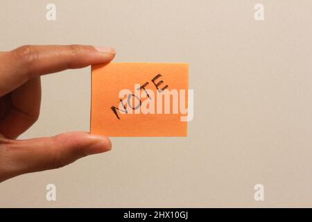 hand holding sticky note in white background Stock Photo - Alamy