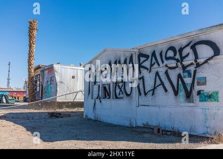 "Momma raised an outlaw" graffiti spray painted on a building, a mobile ...