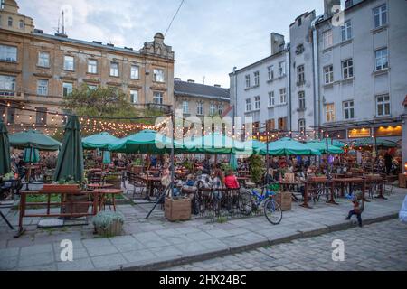 Lviv, Ukraine - May 14, 2021: people at outdoors street cafe flexing talking relaxing Stock ...