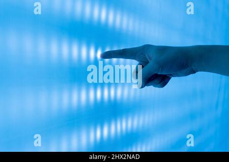 hand and led touch screen blue light science and technology background ...