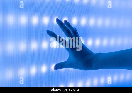 hand and led touch screen blue light science and technology background ...
