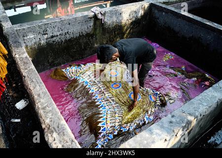 A worker working at a dye factory.The small-scale textile dyeing ...