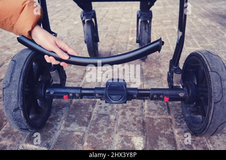 Broken chassis of a baby stroller, damage to the crossbar of the metal ...