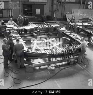 1950s, historical, male workers inside a warehouse filling up motor oil ...
