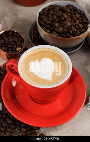 a red cup of latte coffee with coffee bean Stock Photo - Alamy