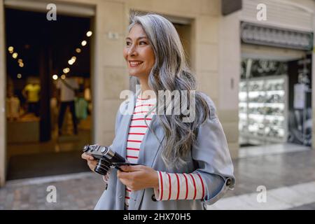 Busy mature lady taking stroll through city Stock Photo - Alamy