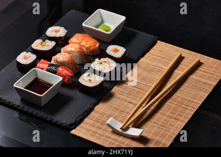 Sushi assortments served with soy and wasabi on a black stone Stock ...