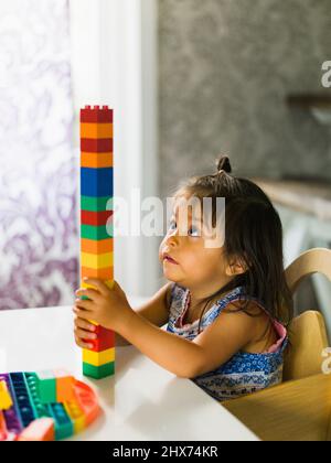 Girl stacking blocks at table Stock Photo - Alamy
