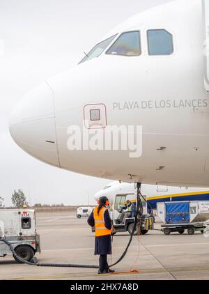 A female worker employee refueling Iberia airlines Airbus A320 twin ...