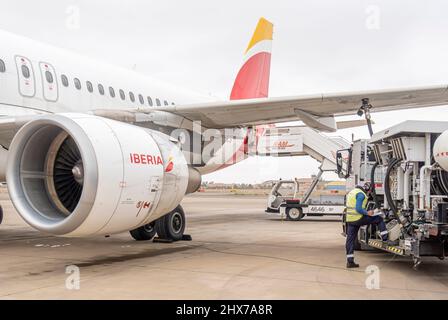 A worker employee refueling Iberia airlines Airbus A320 twin-engine jet ...
