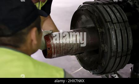 Airport worker checking chassis. Engine and chassis of the passenger ...