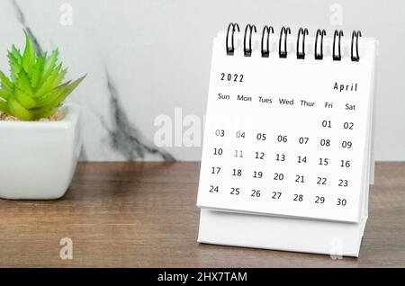 The April 2022 desk calendar with plant on wooden table Stock Photo - Alamy