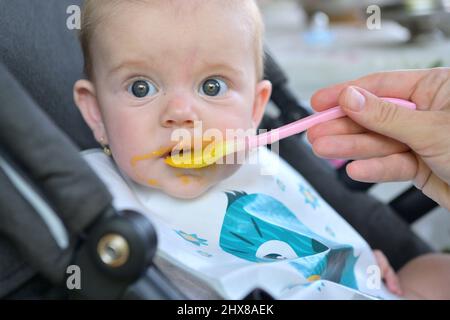 Portrait of a baby's mouth being fed baby gruel Stock Photo - Alamy