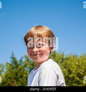 happy boy is smiling and enjoys life under blue sky Stock Photo - Alamy