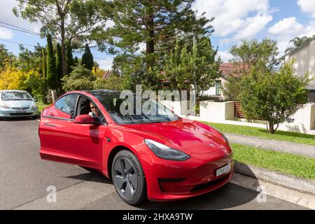 2022 red Tesla model 3 with middle aged lady, model released, stepping ...
