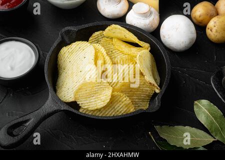 Home made potato chips set, on old dark wooden table, top view flat lay ...