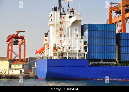 Blue colored cargo ship engaged in international logistics ...