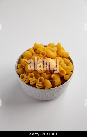Side view of a bowl of organic elbow macaroni isolated on a white ...