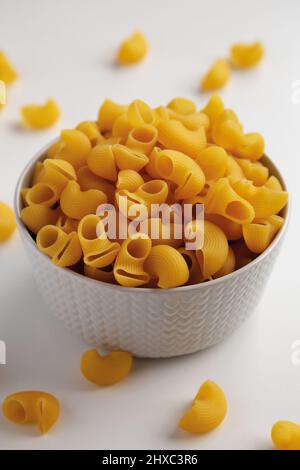 Side view of a bowl of organic elbow macaroni isolated on a white ...