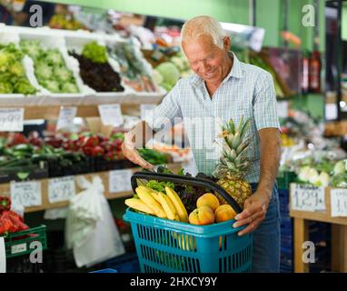 Happy purchaser with basket with fruits and vegetables Stock Photo - Alamy