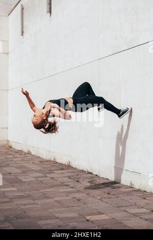 Young Girl Doing Backflip In Studio Stock Photo - Alamy