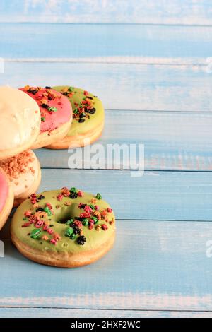 Four assorted glazed donuts with pink, white, chocolate and sugar ...