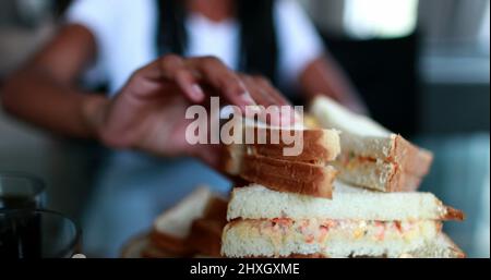 Girl grabbing sandwich from plate. Teen woman eating calorich food carb ...