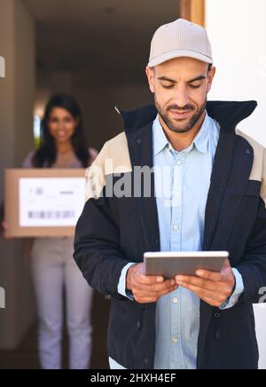 Working with a digitized system. a courier using a digital tablet while ...