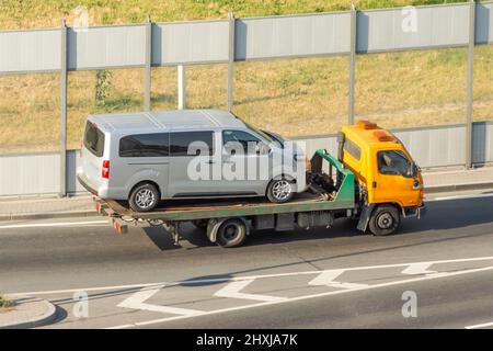 Carriage of a small minibus on the platform tow truck Stock Photo - Alamy