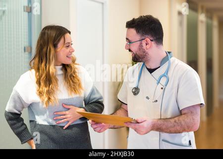 Nurse giving instructions and explaining something to his patient at ...