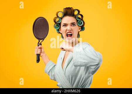 Angry Woman Shouting Holding Frying Pan Over Yellow Studio Background ...