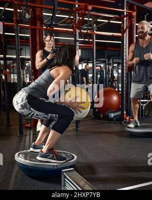 The guys tries to keep his balance on the balancing platform with ...