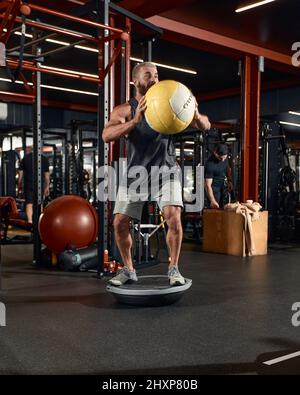 The guys tries to keep his balance on the balancing platform with ...