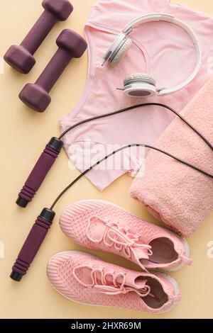 Sports equipment, shoes, t-shirt and headphones on yellow background ...