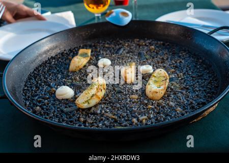 Closeup of Black rice with cuttlefish and young garlic in Spain Stock ...