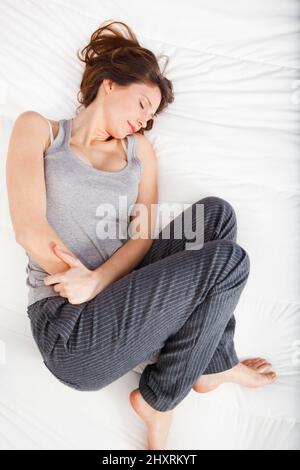 Brunette woman with down syndrome holding folded jeans at donations ...