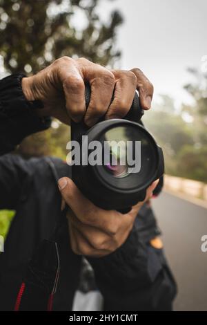 Faceless male photographer taking picture on photo camera near colorful ...
