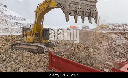 tracked excavator loading the material in a truck Stock Photo - Alamy
