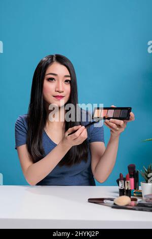 Portrait of asian creator vlogger reviewing studio light on camera for ...