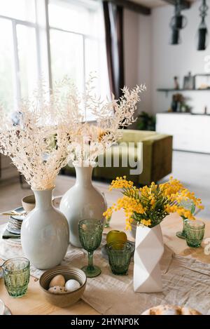 Vase with mimosa flowers on dining table in light room Stock Photo - Alamy