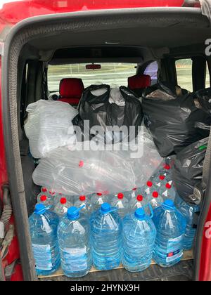 Opened car trunk with packages of food, paint and cable roll for ...