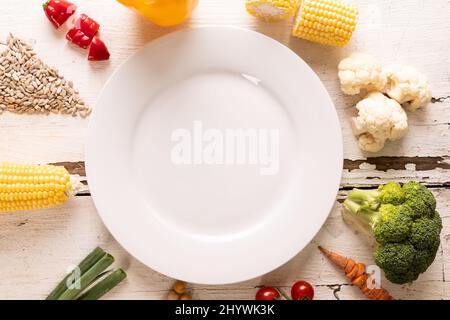Directly above shot of ingredients arranged around white empty plate on ...