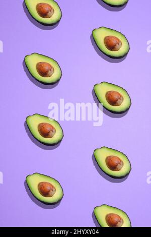 Creative avocado pattern on a purple background with a space for text ...
