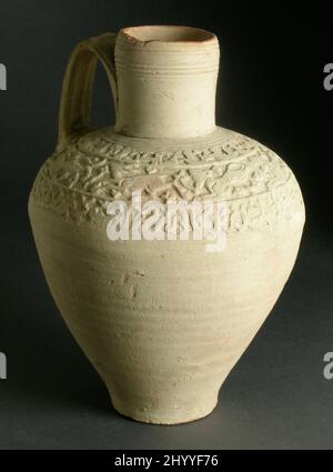 An ancient clay jug with a curved handle and a slightly rounded base ...